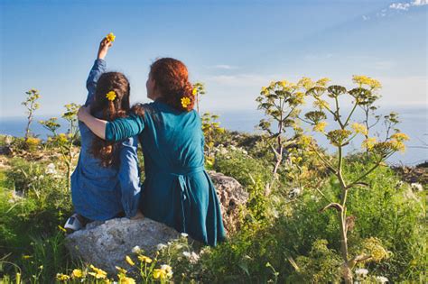 바다를 바라보며 절벽에 꽃을 따기 행복한 어머니와 딸이 앉아 있다 봄에 대한 스톡 사진 및 기타 이미지 봄 꽃 식물 바다 Istock