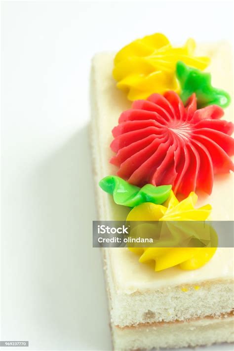 휘저어 진 버터 스폰지 레이어 케이크의 직사각형 조각 크림 설탕을 입 힘 빨강 노란 데이지 꽃과 녹색 잎으로 장식 조리법
