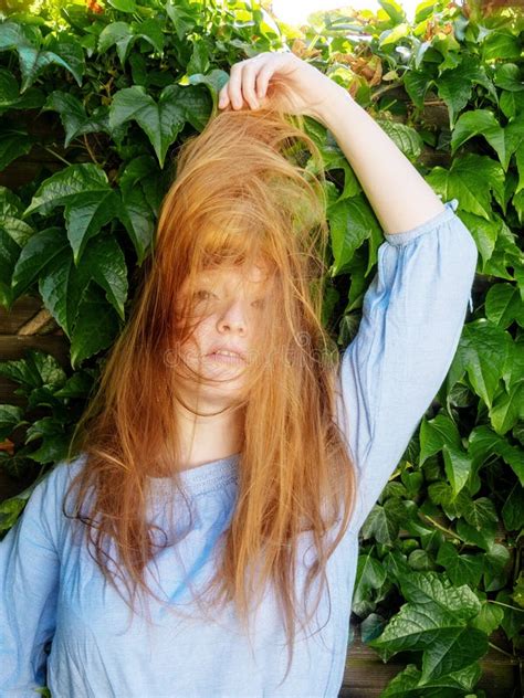 Young Beautiful Redhead Woman Portrait In Blue Dress Plays With Her