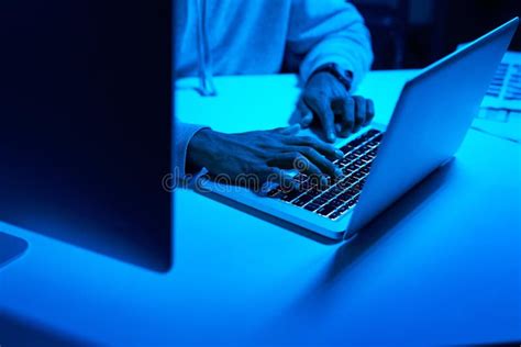 Hes Letting His Fingers Do All The Talking An Unrecognizable Hacker Using A Laptop In The Dark