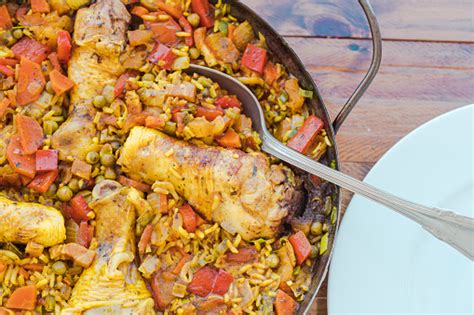 닭고기와 사프란 또는 치킨 빠에야와 쌀쌀과 함께 쌀과 함께 전형적인 스페인 빠에야 팬의 세부 사항 쌀과 흰색 접시 안에 제공하는 국자 전형적인 스페인 음식 0명에 대한 스톡