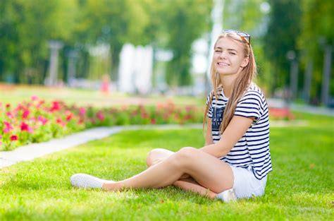 선글라스를 쓴 녹색 꽃이 만개한 여름 공원에서 풀밭에서 포즈를 취하는 행복한 미소 코카서스 십대 소녀의 초상화수평 이미지 구성 개념에 대한 스톡 사진 및 기타 이미지