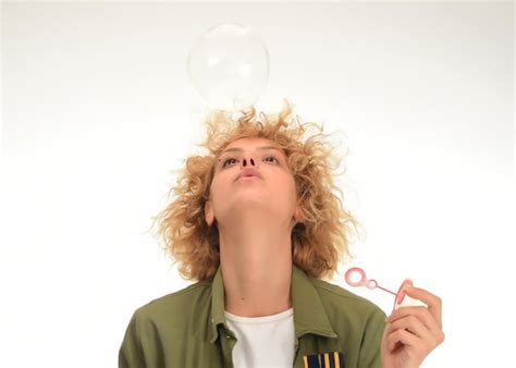 Premium Photo Young Female Model Blowing Soap Bubbles