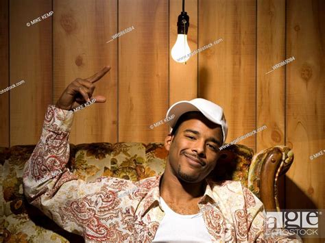 Man Sitting Under Light Bulb Pointing Up Stock Photo Picture And Royalty Free Image Pic