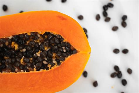 흰색 접시에 씨앗과 반 잘라 잘 익은 파파야 흰색 배경달콤한 파파야 조각 반으로 자른 파파야 건강한 이국적인 과일 채식 음식 0