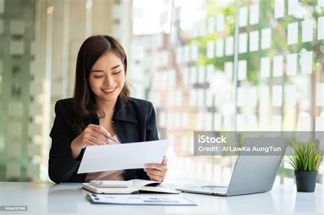 현대 사무실에서 노트북 컴퓨터를 사용하여 일하는 아시아 사업가 재무 그래프 및 부동산 투자 데이터가 포함 된 계정 분석 보고서를 작성하십시오 금융 및 세금 시스템 개념 회계