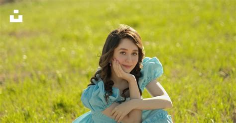 파란 드레스를 입은 여자가 풀밭에 앉아 있다 사진 Unsplash의 무료 꽃 이미지