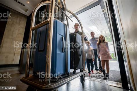 친절한 벨홉 푸시 카트 와 손님 가족 수하물 카트 에 체크인 준비 호텔 호텔에 대한 스톡 사진 및 기타 이미지 호텔 호텔