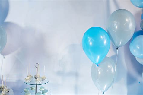 파란색과 투명한 풍선 디저트 마카롱 연한 파란색 천에 유리 쟁반에 케이크가 있는 축제 배경 아기 소년 또는 성별 파티를 위한 항해 색상의 주제별 생일 파티 0명에 대한 스톡