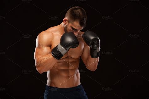 Muscular Young Man With Perfect Torso With Six Pack Abs In Boxing Gloves Is Showing The