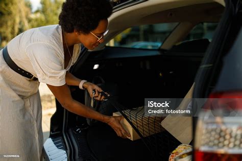 자동차 트렁크에 패키지를 싣고 메쉬 라이닝으로 제자리에 고정하는 여성 40 44세에 대한 스톡 사진 및 기타 이미지 40 44세 개인 장식품 낮 Istock