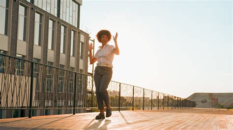 여성 실루엣 햇빛 도시 유효한 장난이 심하다 행복 소녀 아프리카 계 미국인 사업가 걷기 댄스 음악에 맞추다 회전하다 세상에 알리다 성취 성공 비즈니스 우먼 댄스 야외로 나가