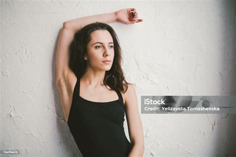 수영복을 입고 운동 빌드의 아영 스포츠 여성의 초상화 여자는 댄스 스튜디오에서 시간을 보낸다 아름다움 여자 에 스포츠 착용 스탠드 에 벽 벽 배경에 포즈를 취하는 바디 수트