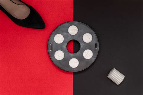 3d 프린터용 3d 프린팅 필라멘트 릴과 그리스 기둥과 신발의 인쇄된 부분이 검은색 빨간색 배경에 있습니다 가정에서 미래의 인쇄 신발 및 액세서리의 개념 0명에 대한 스톡