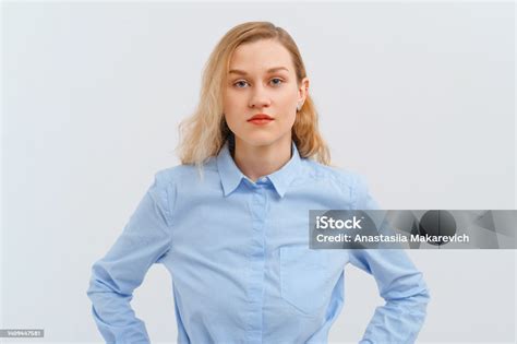파란 셔츠를 입은 자신감 넘치는 젊은 여성 진지한 얼굴로 카메라를 바라보며 하얀 배경 위에 서 서 있었다 20 24세에 대한 스톡 사진 및 기타 이미지 Istock