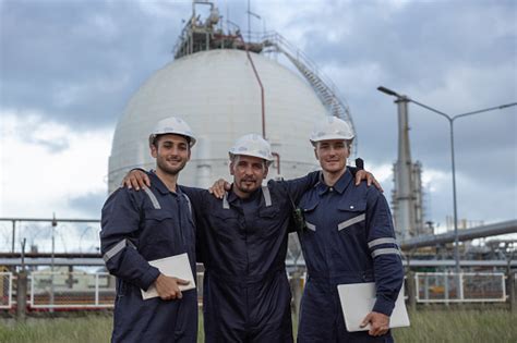 팀의 성공 전문 전기 엔지니어 안전 유니폼 탱크 정제 석유 화학 산업 공장에 서서 서로를 포옹합니다 25 29세에 대한 스톡 사진 및 기타 이미지 Istock