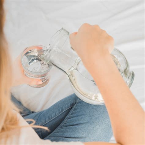 Menina Loira Enchendo O Copo De água Foto Grátis