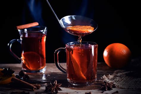 어두운 배경 소박한 나무 테이블에 계 피 스타 아니 스 정 향 오렌지 조각 같은 크리스마스 향신료와 유리 찻잔에 부 어 뜨거운