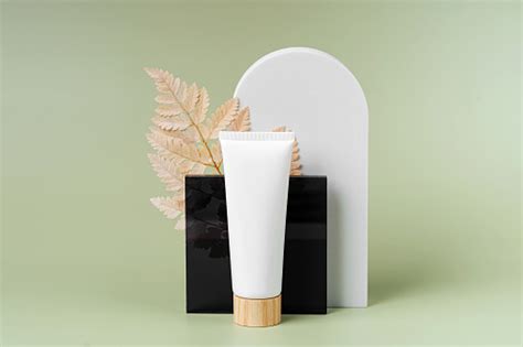 녹색 배경에 잎과 기하학적 형태가있는 크림 튜브 모형 브랜딩 및 포장 프리젠 테이션을위한 천연 스킨 케어 뷰티 제품 0명에 대한