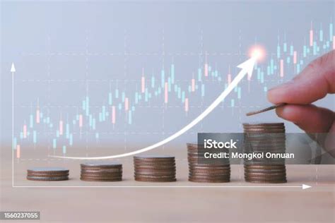 인간의 손으로 동전을 쌓고 나무 테이블에 가상 트렌드 그래프를 올려 놓는 개념으로 돈을 절약한다 사업 투자 성장 및 이익 증가 개념 Earnings Before
