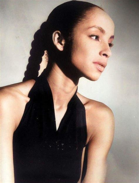 A Woman In A Black Halter Top Is Posing For The Camera