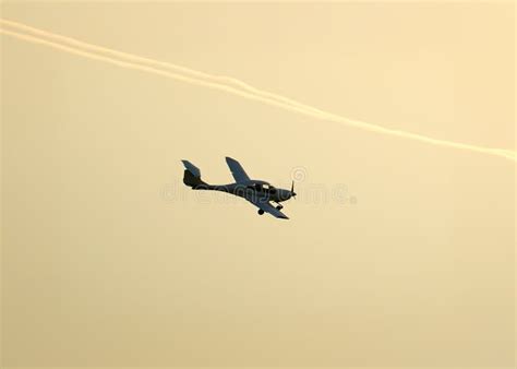 Single Propeller Plane Against A Vibrant Evening Sky In Flight Stock