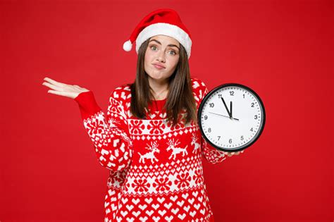 스웨터 크리스마스 모자에 혼란 젊은 산타 여성 20 S 밝은 빨간 색상 배경 스튜디오 초상화에 고립 된 손을 확산 시계를 개최 새해 축하 메리 홀리데이 컨셉 계절에 대한