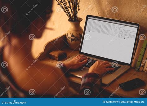 Back View Of Caucasian Female Programmer Siting At Desk Using Laptop With Coding On Screen