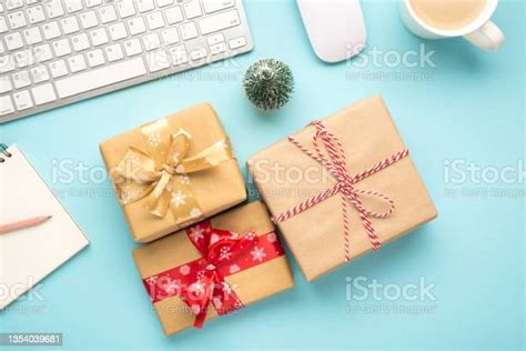 카피북 연필 3 개의 선물 상자 키보드 컴퓨터 마우스 전나무 장난감과 고립 된 파스텔 블루 배경에 뜨거운 음주 컵의 상단 보기