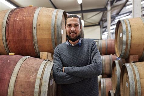 와이너리 생산 및 관리자는 알코올 공장 제조 및 창고에서 나무 위스키 통 음료 용기 및 저장 시설을 갖추고 있습니다 산업 와인 저장고에서 행복한 와인 메이커의 초상화 업주에