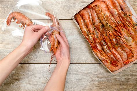 상자에서 셀로판 플라스틱 냉동고 가방에 생 큰 새우 새우를 넣는 여성 복사 공간이있는 나무 배경에 가방에 대한 스톡 사진 및 기타 이미지 Istock