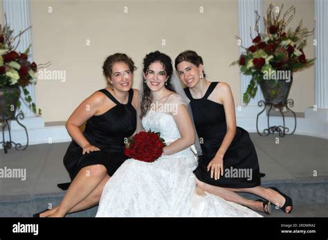Bride And Her Two Sisters Sit On The Steps Of The Wedding Chapel Two
