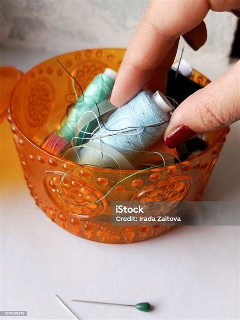 한 여자의 손이 실과 바늘이 들어 있는 상자에서 푸른 실 한 가닥을 꺼냅니다 재봉 및 의류 수리 개념 배경 텍스트를 위한 공간 강철에 대한 스톡 사진 및 기타 이미지