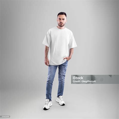 청바지를 입고 수염을 기른 남자에 흰색 오버사이즈 티셔츠의 모형 주머니에 손 전체 길이 정면 보기 스튜디오 배경에 고립되어 있습니다 T 셔츠에 대한 스톡 사진 및 기타