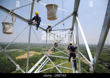 Workers Next To Transmission Line Tower Stock Photo Alamy