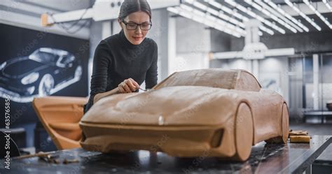 Portrait Of A Female Automotive Designer Sculpting A D Clay Model Of New Production Car Babe