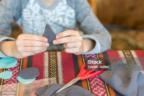 바늘과 실을 가진 어린 소녀 만들기 펠트로 만든 꼬마 소녀 만들기 펠트로 만든 꼬마 소녀 어린 소녀는 회색 마우스를 세운 어린 소녀를 세우는 장난감 겨울에 대한 스톡 사진