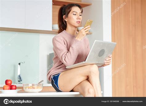 Joven Hermosa Asiática Ladyboy Sentado Mesa Cocina Trabajando Ordenador Portátil fotografía de