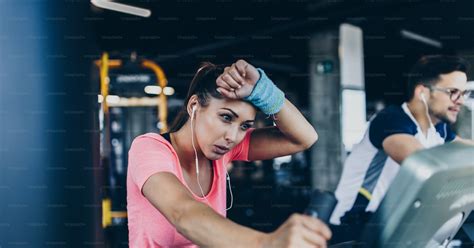 젊고 매력적인 여자와 남자가 피트니스 체육관에서 자전거를 타고 있다 그들은 사이클링 머신을 타면서 다리를 운동하고 유산소 운동을 합니다 사진 Unsplash의