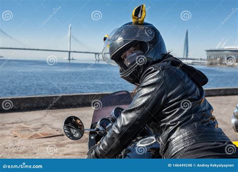 Pretty Biker Girl In Leather Jacket And Black Helmet With Mask On Face Looking Back While