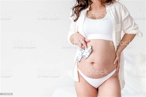 분홍색 셔츠를 입은 임산부가 하얀 배경에 큰 배를 만진다 모성 임신 및 아기 대기의 개념 복사 공간 배너 가족에 대한 스톡 사진 및 기타 이미지 Istock