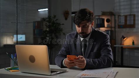 Adult Business Man Manager Sitting At Desk Working On Laptop In Office Overtime In Evening
