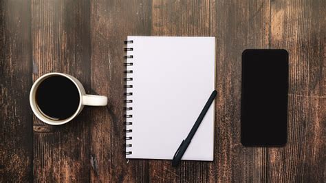 백지 공책 커피 한 잔이 있는 작업 테이블 배경의 맨 위 보기 플랫 누워 다채로운 종이 바인더 클립 메모장과 펜 데스크탑 모형 작업 공간 문구류 스마트폰 0명에 대한 스톡