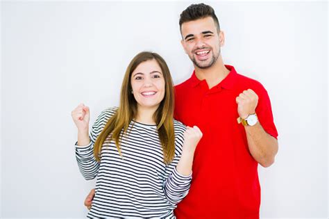 흰색 고립 된 배경을 통해 함께 젊은 아름다운 부부는 팔을 들고 눈을 뜨고 성공에 놀랐고 놀랐습니다 우승자 컨셉 2명에 대한 스톡 사진 및 기타 이미지 Istock