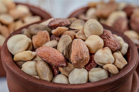 오래 된 소박한 테이블에 견과류와 말린 과일을 섞어 줍니다 골드 피스타치오 캐슈 헤이즐넛 아몬드 및 차 음식 배경입니다 0명에