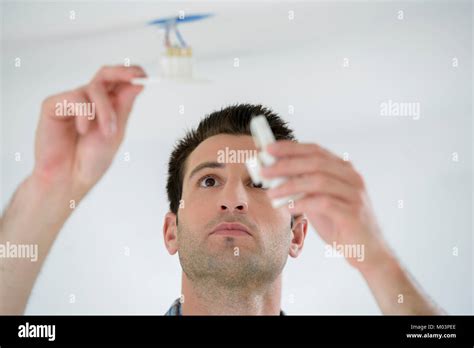 Man Fitting Light To Ceiling Stock Photo Alamy