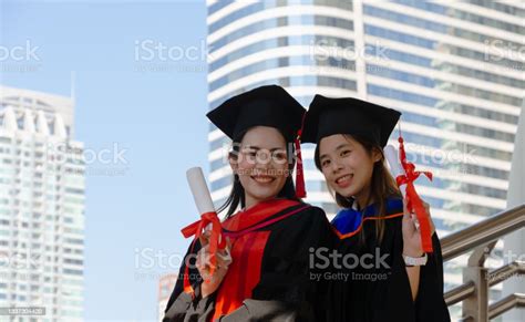 졸업한 두 명의 여성 친구들이 졸업장을 손에 들고 미소로 성공을 축하합니다 2명에 대한 스톡 사진 및 기타 이미지 2명 건물 외관 교육 Istock