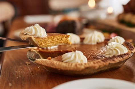 추수 감사절 디저트 및 축하를 위해 가정의 식탁에 호박 파이가 든 칼 축제 잔치나 식사를 위해 아파트에서 케이크를 클로즈업한 음식 전통 및 사교 행사 0명에 대한 스톡 사진