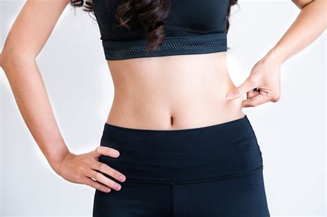 그녀의 아랫 배를 만지고 운동복에 젊은 여자 그녀의 아랫 배를 만지고 운동복에 젊은 여자 가냘픈에 대한 스톡 사진 및 기타