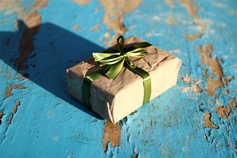 빈티지 선물 상자와 올리브 실크 리본 리본 리본 블루 오래 된 나무 배경에 그림자가 있는 녹색 활이 있는 공예 용지에 상자를 선물합니다 휴일 개념 클로즈업 파스텔 틴트 0